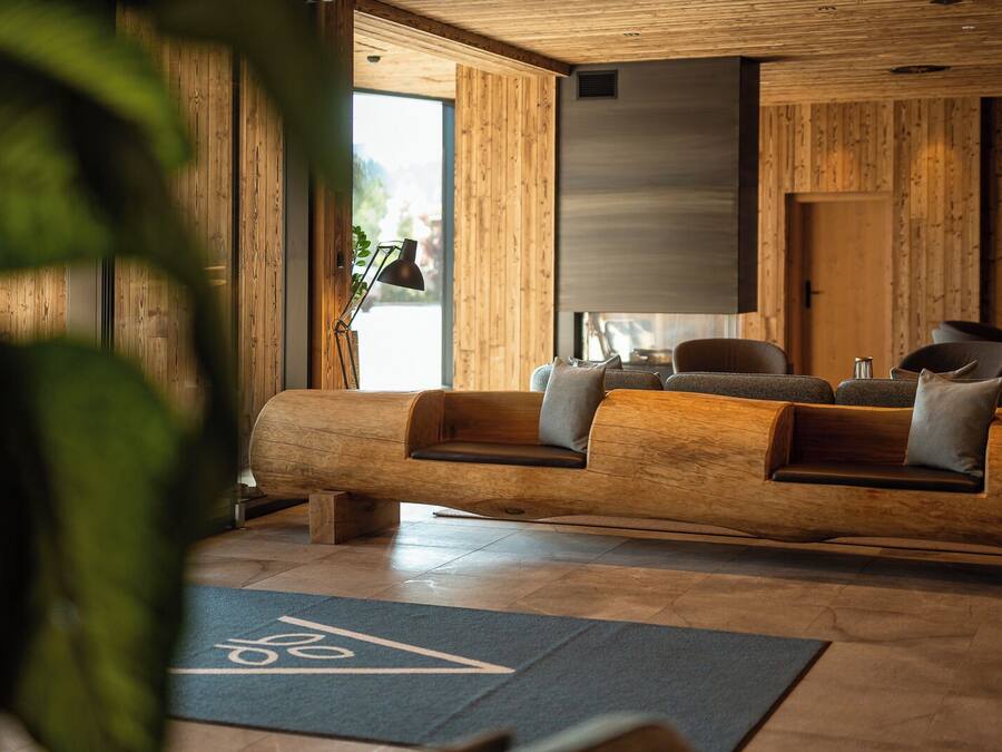 Um interior moderno com um banco de tronco de madeira, uma janela ampla e um design minimalista.
