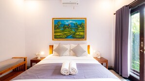 Quarto de hotel com uma cama grande, duas mesas de cabeceira com luminárias, um quadro na parede e uma janela com cortinas.