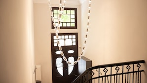 Uma escadaria com corrimão metálico e um candeeiro decorativo.