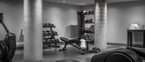 Uma academia com equipamentos de musculação, halteres e bolas de exercício.
