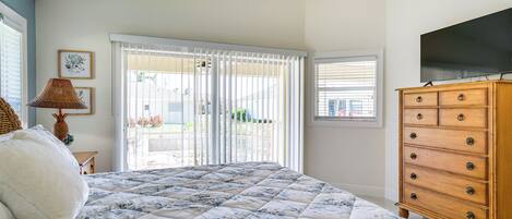 Quarto com cama, cômoda, ventilador de teto e janela com persianas.