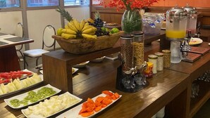 Uma mesa de buffet com frutas, legumes e bebidas variadas.