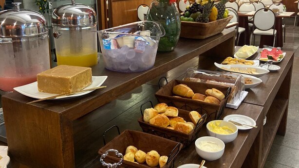 Disposição de buffet com diversos alimentos e um grande arranjo floral.