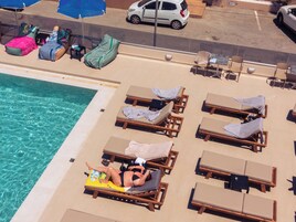 Uma área na piscina com espreguiçadeiras e piscina.