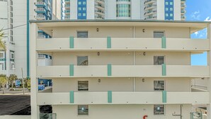 Um hotel com vários andares e uma piscina no nível do térreo.