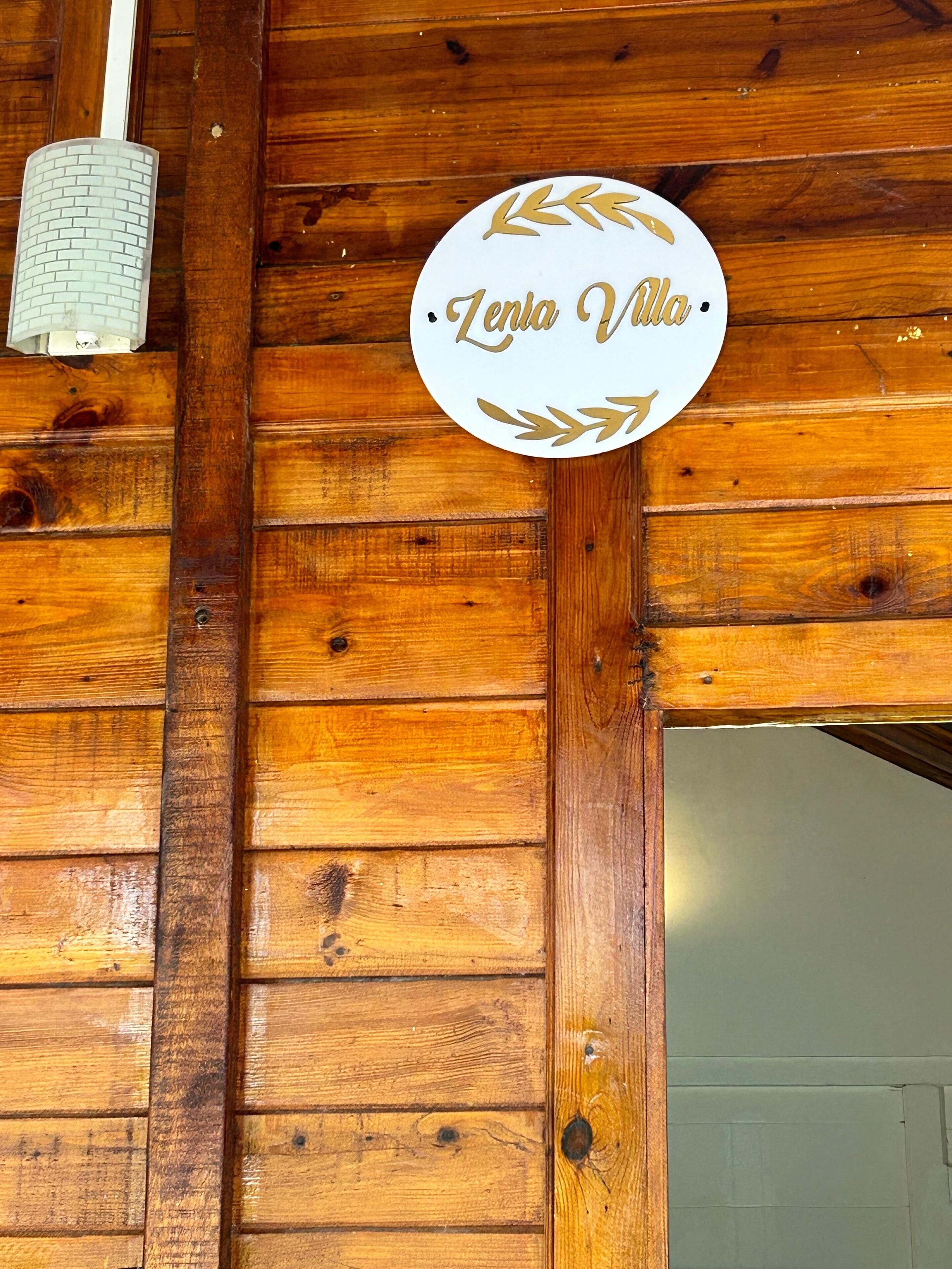 Uma cabana de madeira com uma placa que diz 'Lenya Villa'.