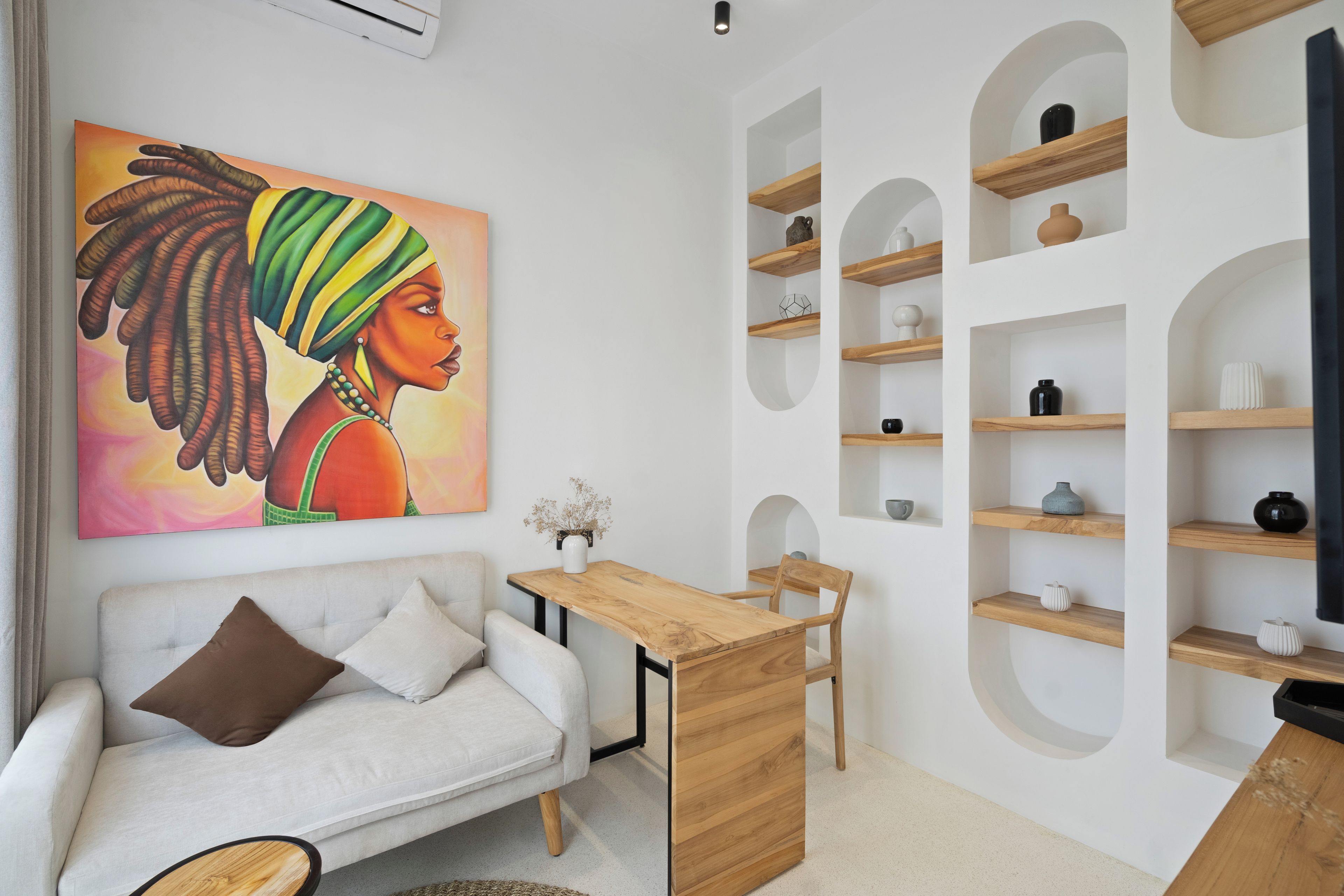 Uma sala de estar moderna com sofá, mesa de jantar e estantes embutidas decoradas com objetos.