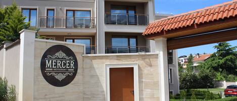 Um hotel chamado 'Hotel Vemara City' com uma placa indicando 'Mercer Restaurant' em frente.