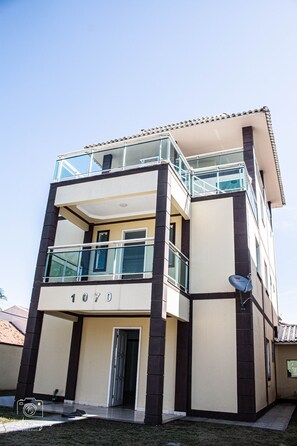 Um edifício de vários andares com uma varanda no andar superior, uma antena parabólica e o número 1070 na fachada.