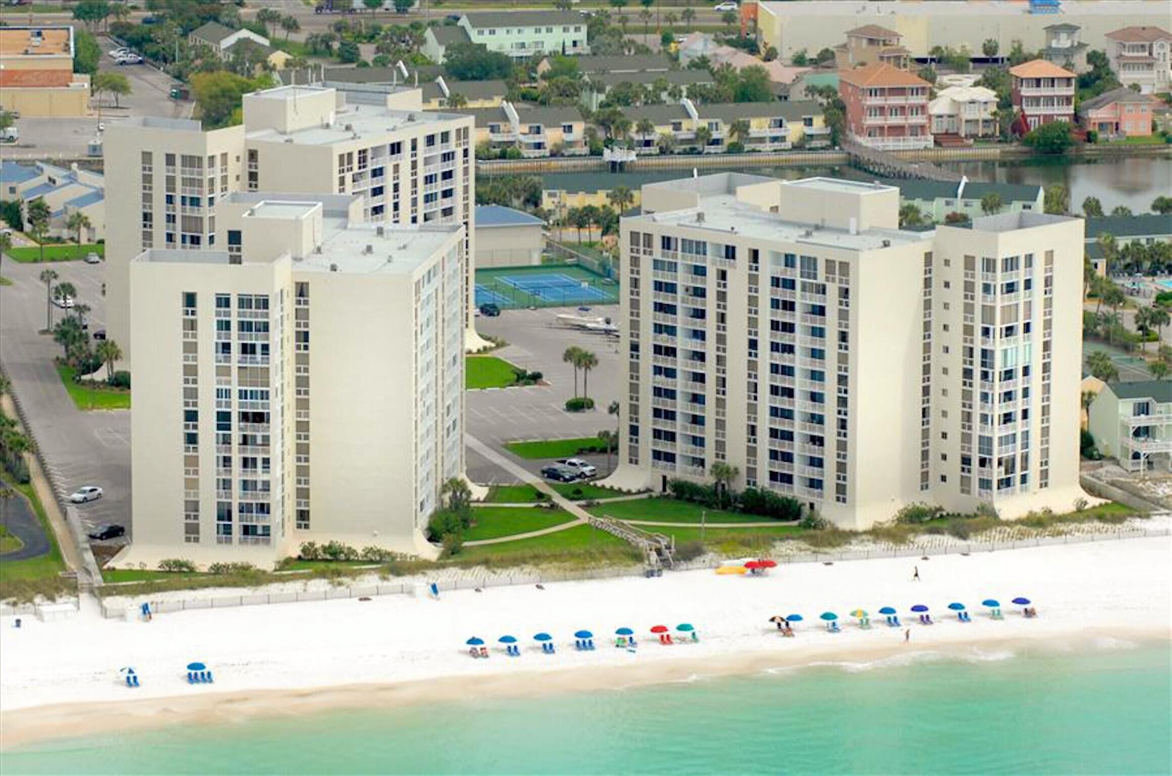 Um hotel moderno com vários andares, vista para a praia e área de piscina.