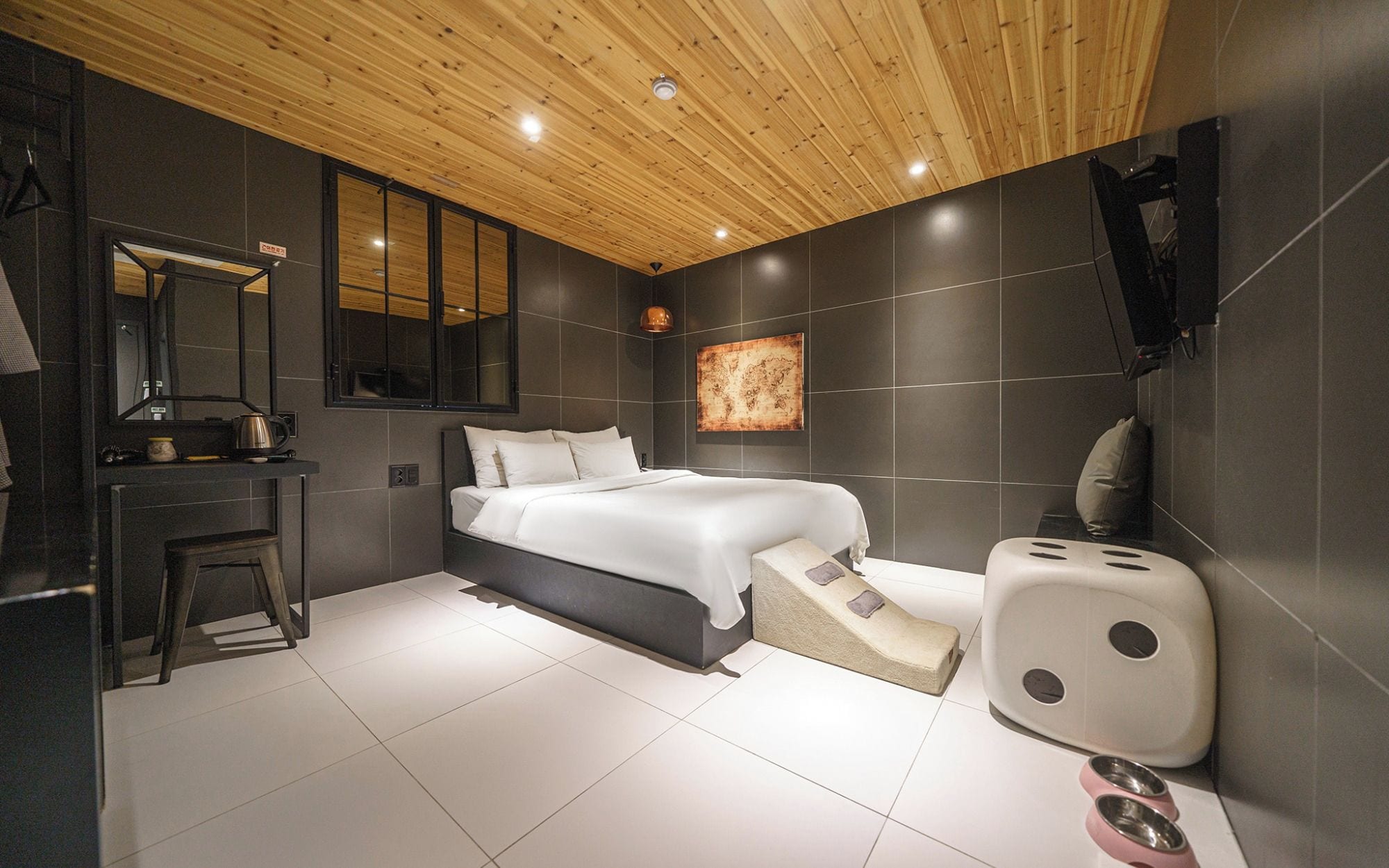 Quarto moderno com cama, escrivaninha e um espelho grande.