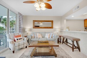 Uma sala de estar moderna com um sofá, poltronas, uma mesa de centro e um espaço de refeições.