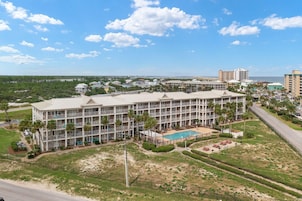 Um hotel com vários andares, piscina e vista para a praia.