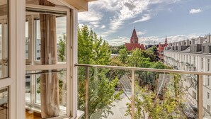 Varanda com vista para uma igreja e edifícios residenciais.