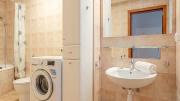 Apartamento clássico | Banheiro | Banheira, toalhas de banho, sabonete, shampoo