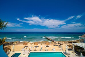 Praia particular, areia branca, espreguiçadeiras, guarda-sóis 