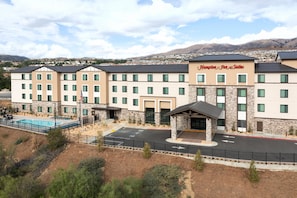 Um hotel Hampton Inn & Suites com piscina, área de estar externa e vista para as colinas ao redor.