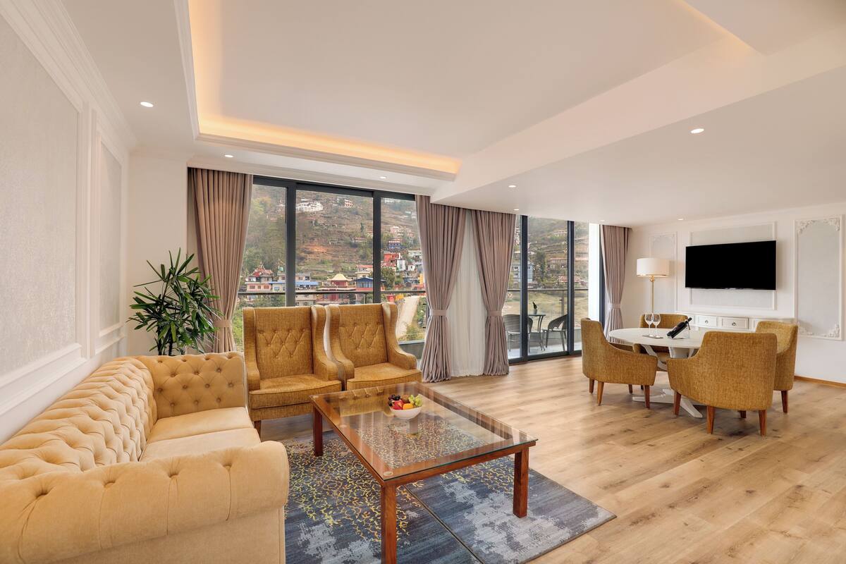 Uma sala de estar moderna com um sofá, uma mesa de centro e uma área de jantar com cadeiras e uma TV.