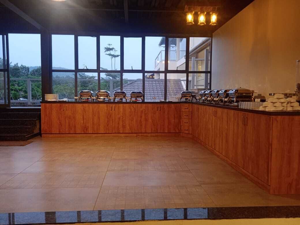 Um quarto espaçoso com balcão de madeira, janelas amplas e vista para o exterior.