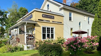 Um edifício de dois andares com uma padaria chamada Boulangerie e um café chamado Les Amis.