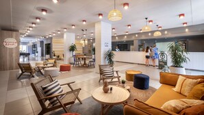 Um hall amplo com móveis modernos, uma mesa de recepção e uma área de refeições.