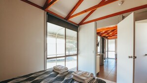 Quarto com uma cama grande, janela e vista para o exterior.