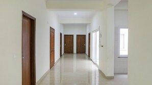 Um corredor com portas de madeira e chão de azulejos.