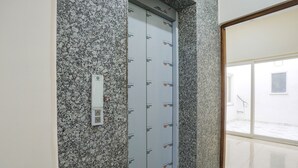 Um elevador com painel de comando e porta com logotipo.