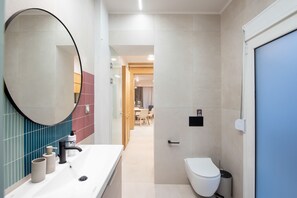 Apartamento urbano | Banheiro | Chuveiro, chuveiro com efeito de chuva, produtos de toalete de grife 