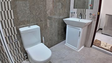 Quarto casal básico | Banheiro | Chuveiro, chuveiro com efeito de chuva, chinelos, bidê