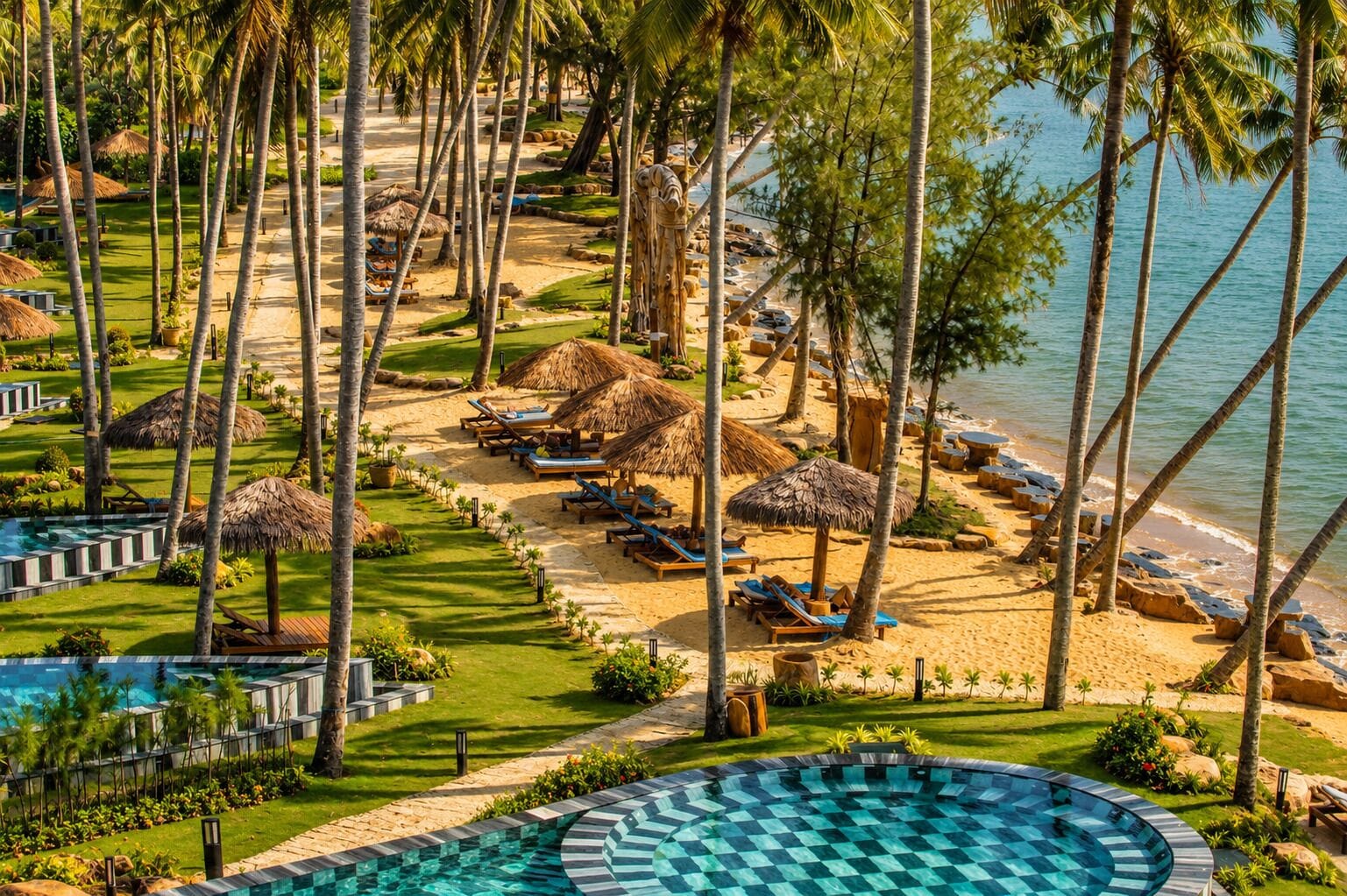 Um resort com piscina, área de praia e palmeiras.