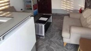 Uma sala de estar moderna com um sofá, uma televisão e um ventilador de teto.