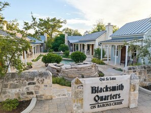 Um muro de pedra com uma placa que diz 'Blacksmith Quarters on Barons Creek'.