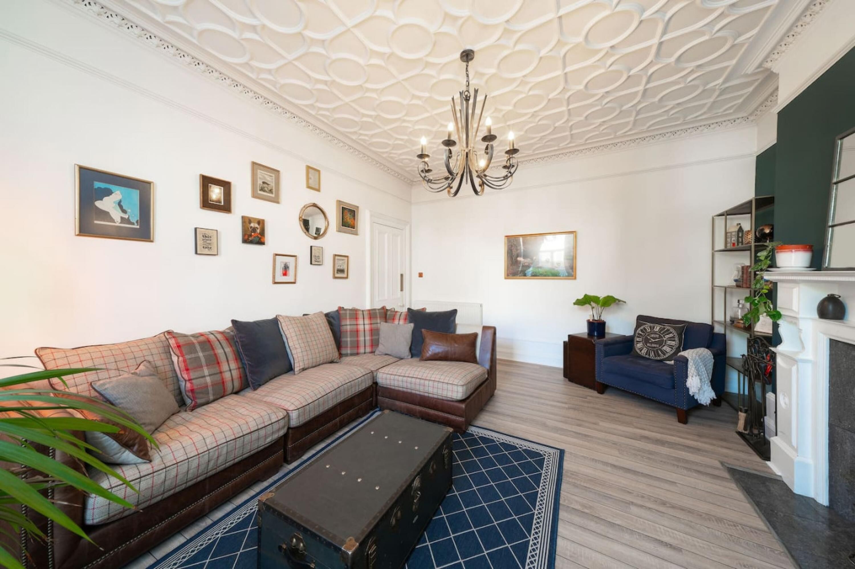 Uma sala de estar com sofá seccional, mesa de centro e lareira.