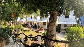 Um resort com vários edifícios brancos, um caminho pavimentado e vegetação exuberante.