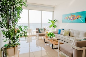 Uma sala de estar moderna com um sofá, mesa de centro e plantas em vasos.
