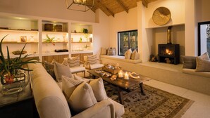 Uma sala de estar aconchegante com sofá, mesa de centro e estantes com plantas.