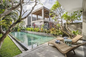 Uma área de piscina com espreguiçadeiras e um edifício em construção.