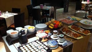 Um buffet com diversos alimentos e acompanhamentos.