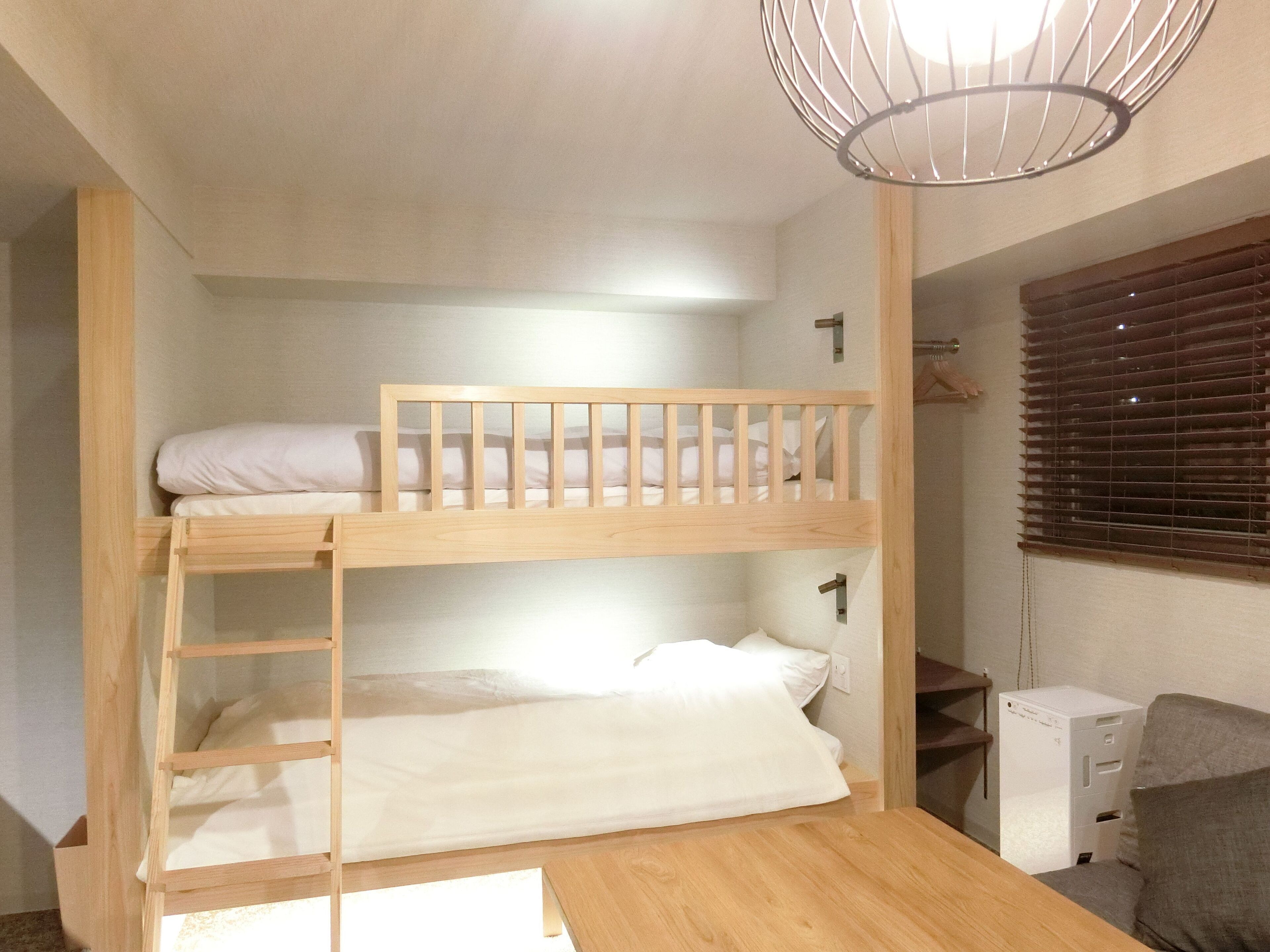 Quarto com beliche, mesa de madeira, escrivaninha e guarda-roupa.
