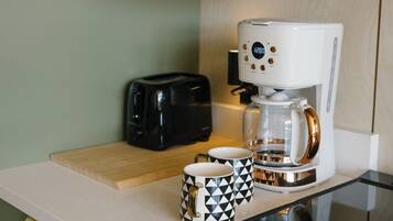 Uma cozinha equipada com micro-ondas, torradeira, cafeteira e fogão.