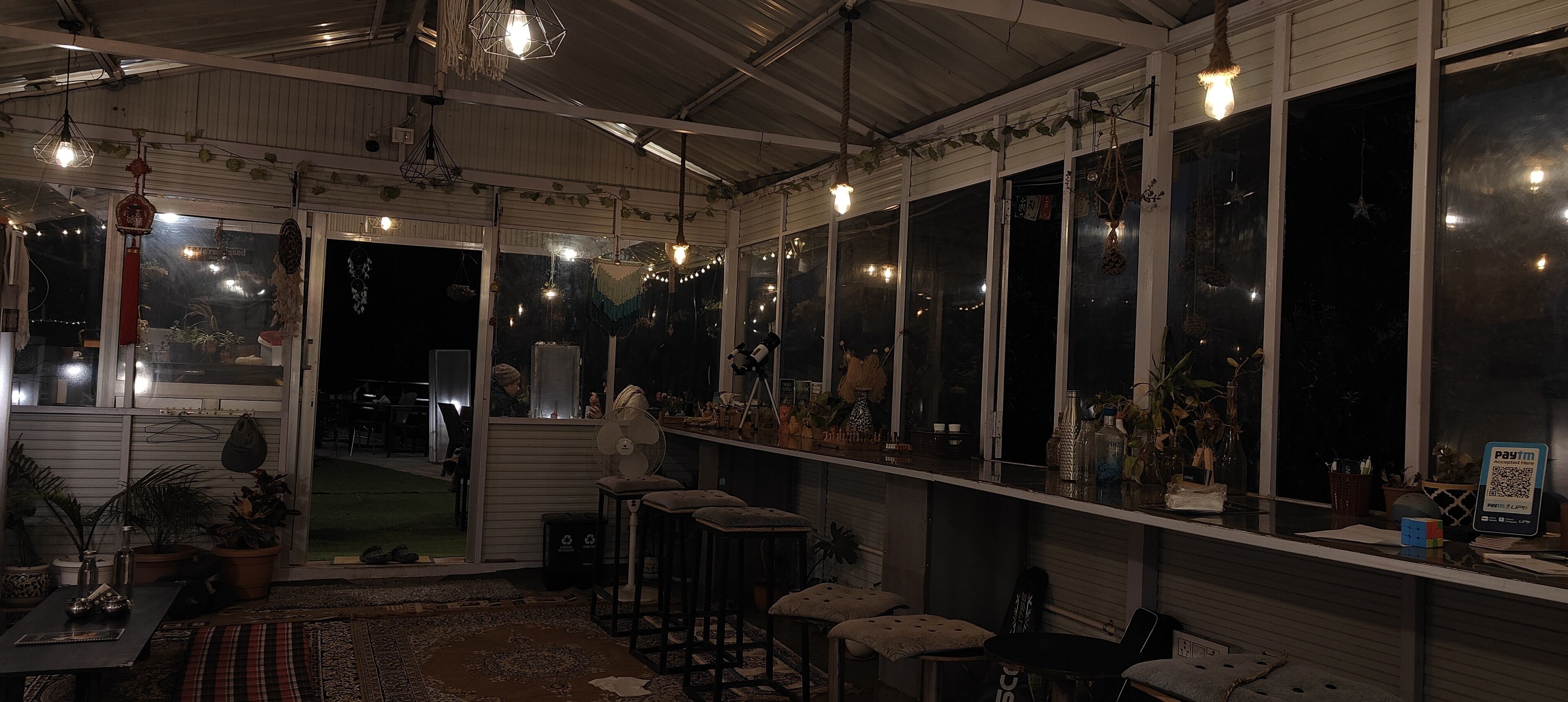 Um quarto aconchegante e bem iluminado, com área de bar, janelas amplas e diversas decorações.