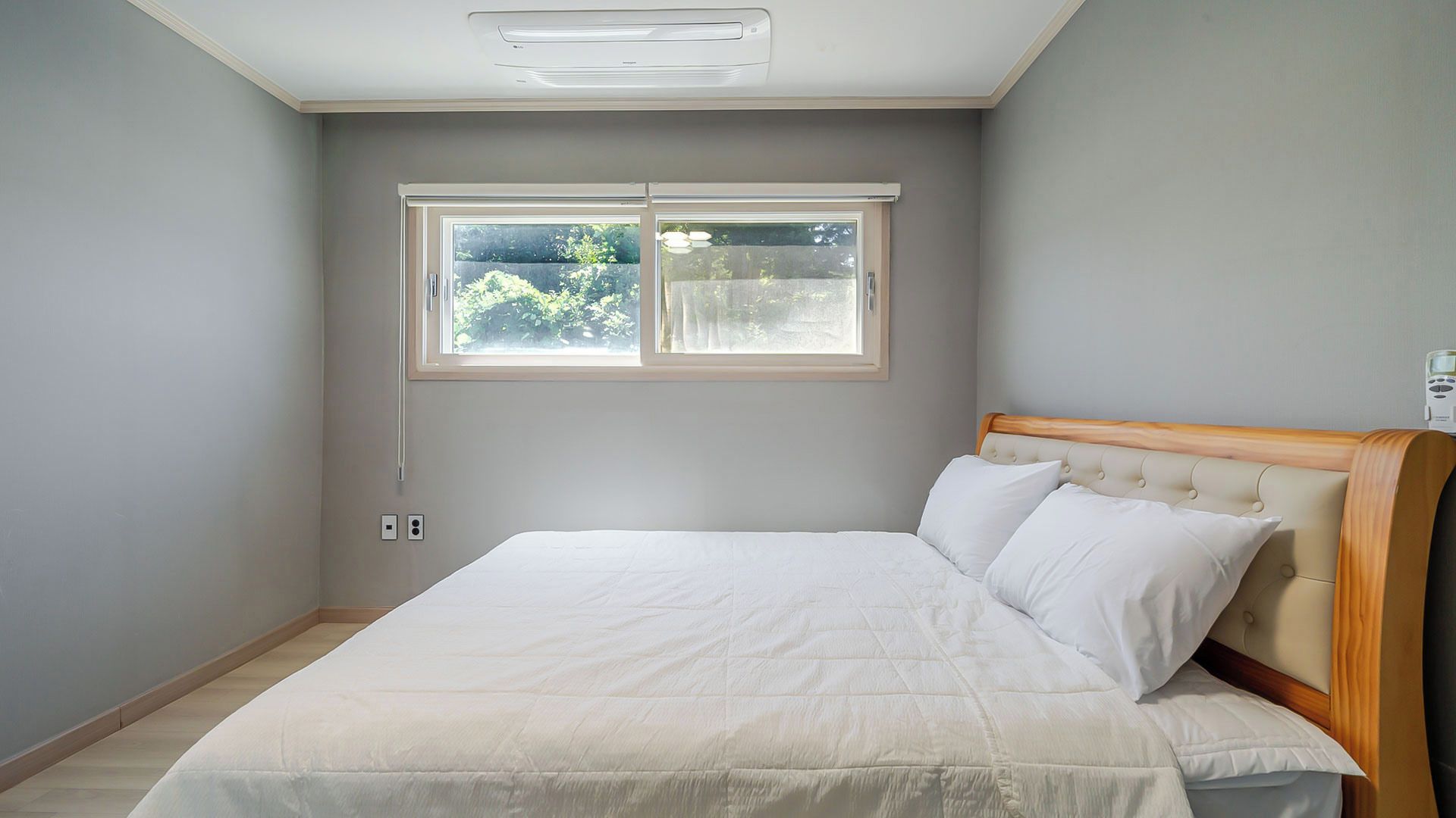 Quarto com cama, janela e luminária no teto.