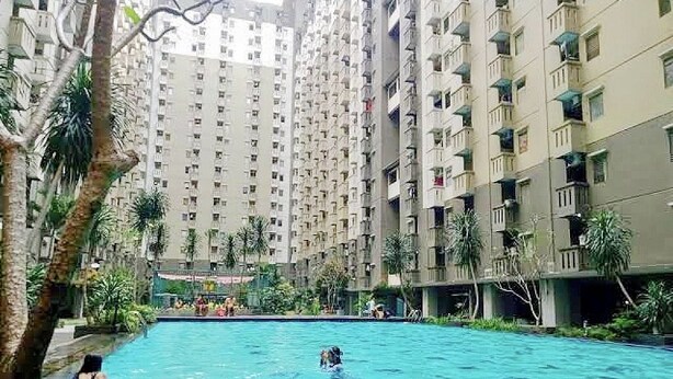 Piscina cercada por edifícios residenciais altos.