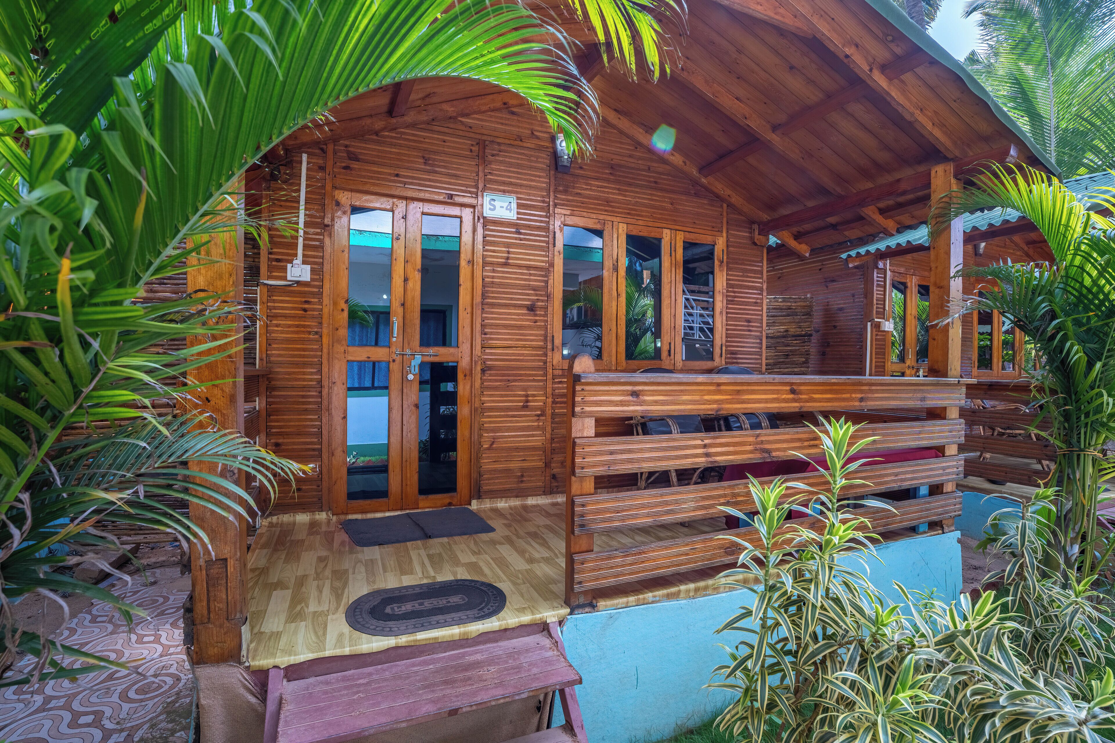 Uma cabana de madeira com varanda, porta e janela.