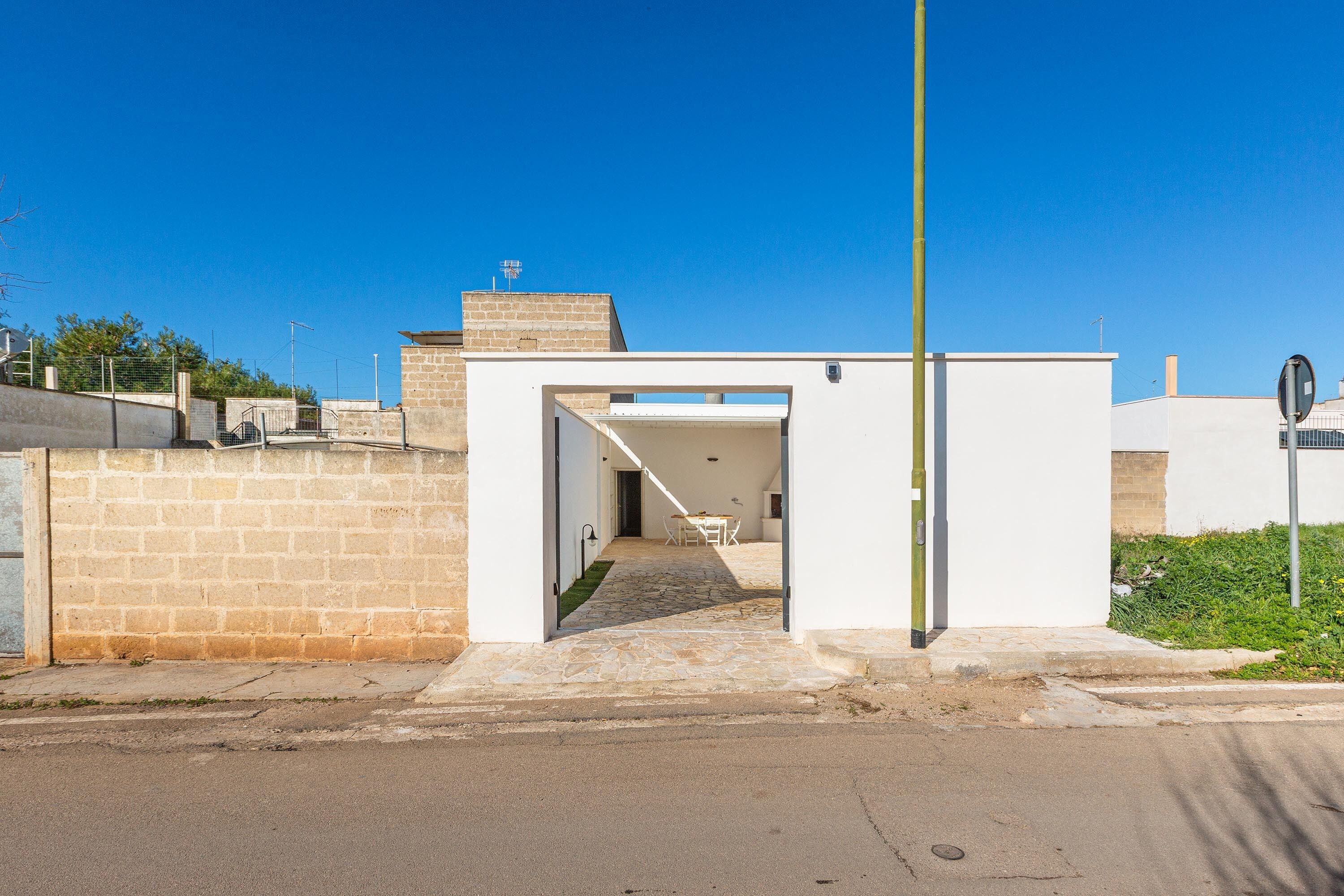 Um edifício moderno com um caminho de pedra que leva a uma porta branca.