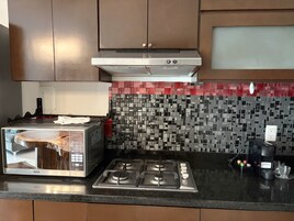 Cozinha com exaustor de aço inoxidável, torradeira e fogão a gás.