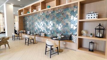 Um interior moderno com uma parede estampada com flores, prateleiras de madeira e áreas de estar.