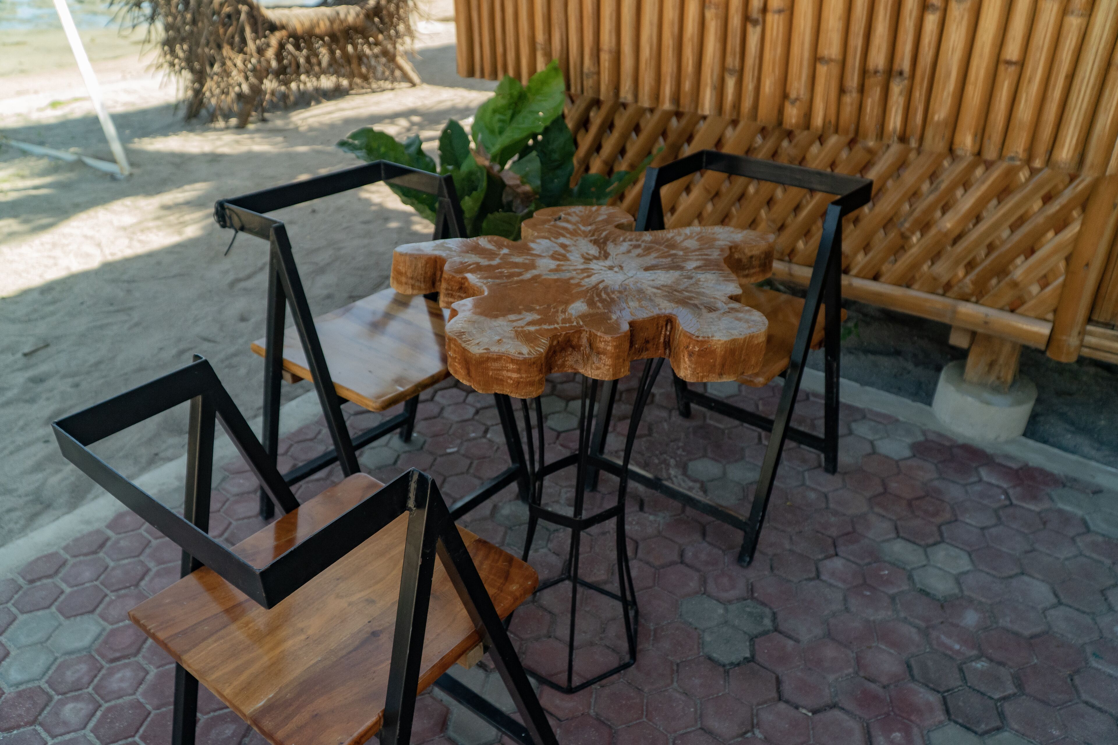 Uma mesa de madeira com design único, rodeada por cadeiras com estrutura de metal.