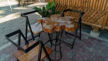 Uma mesa de madeira com design único, rodeada por cadeiras com estrutura de metal.